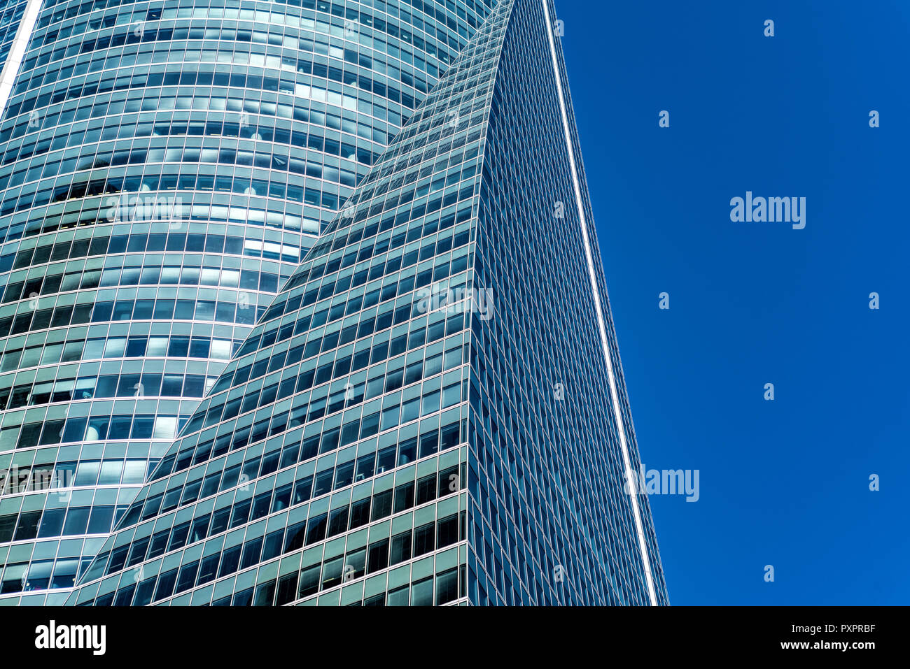 Skyscraper made from glass and metal in downtown on a blue sky ...