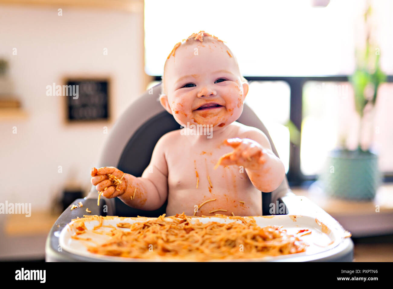 Little baby girl eating her spaghetti dinner and making a mess Stock ...