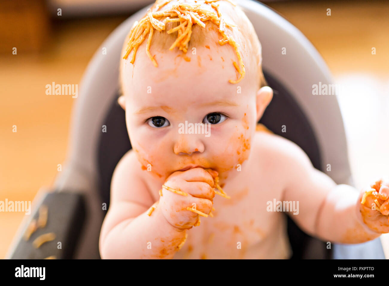 Little baby girl eating her spaghetti dinner and making a mess Stock ...