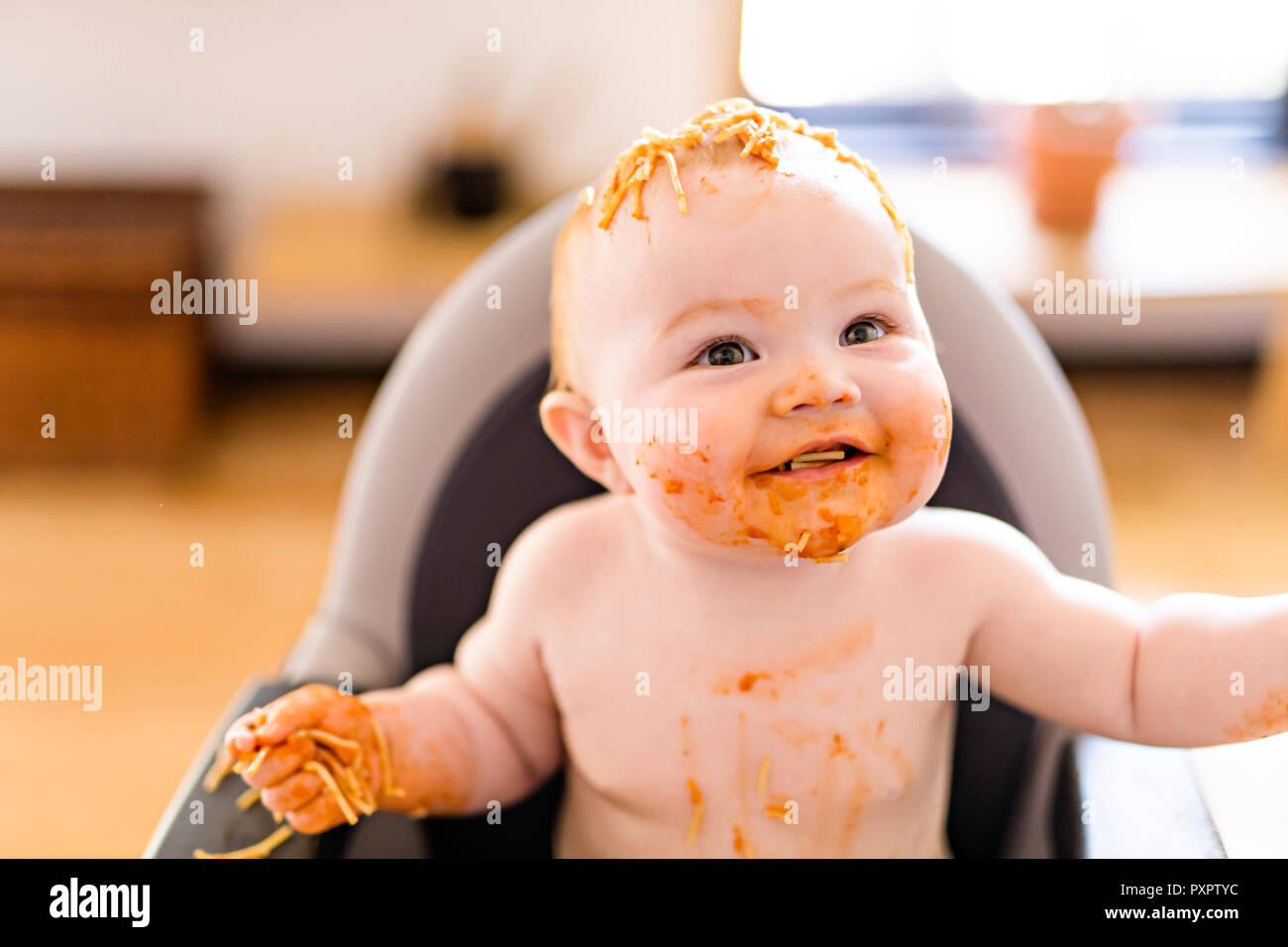 Little baby girl eating her spaghetti dinner and making a mess Stock ...