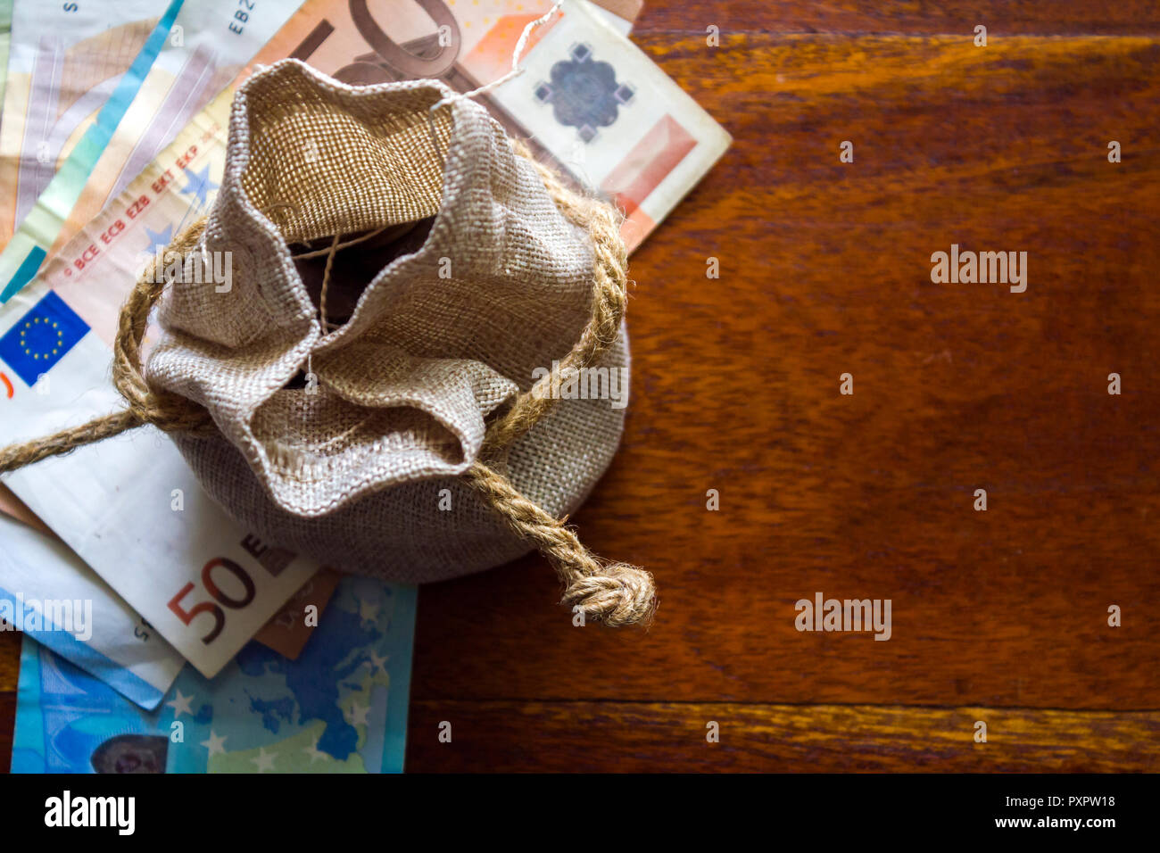 Money bag over euro banknotes Stock Photo - Alamy