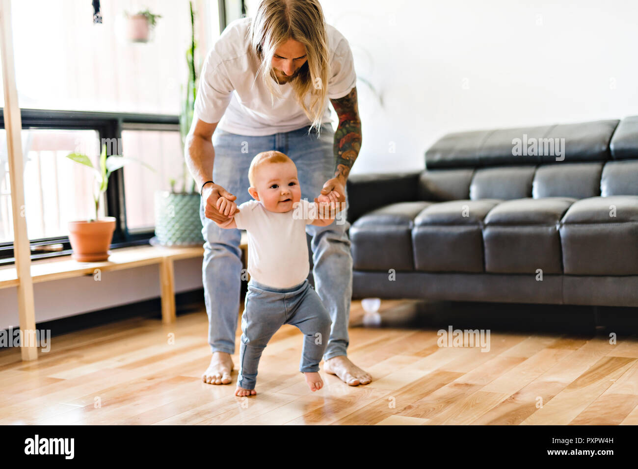 Father help Baby Daughter Take First Steps At Home Stock Photo - Alamy
