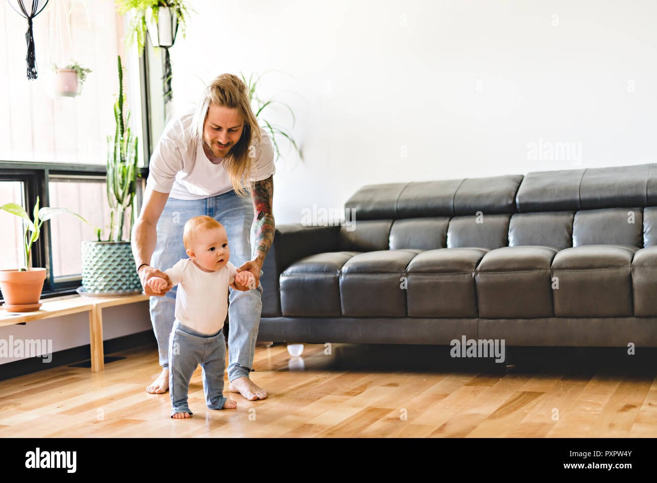 Father help Baby Daughter Take First Steps At Home Stock Photo - Alamy