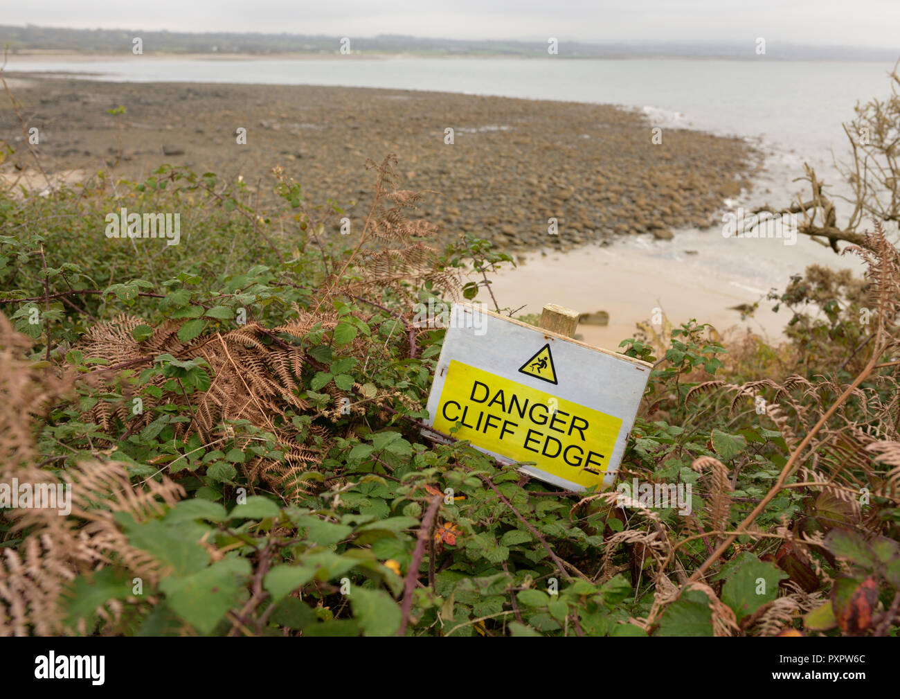 Yellow and white Danger cliff edge warning sign on wales coast path ...