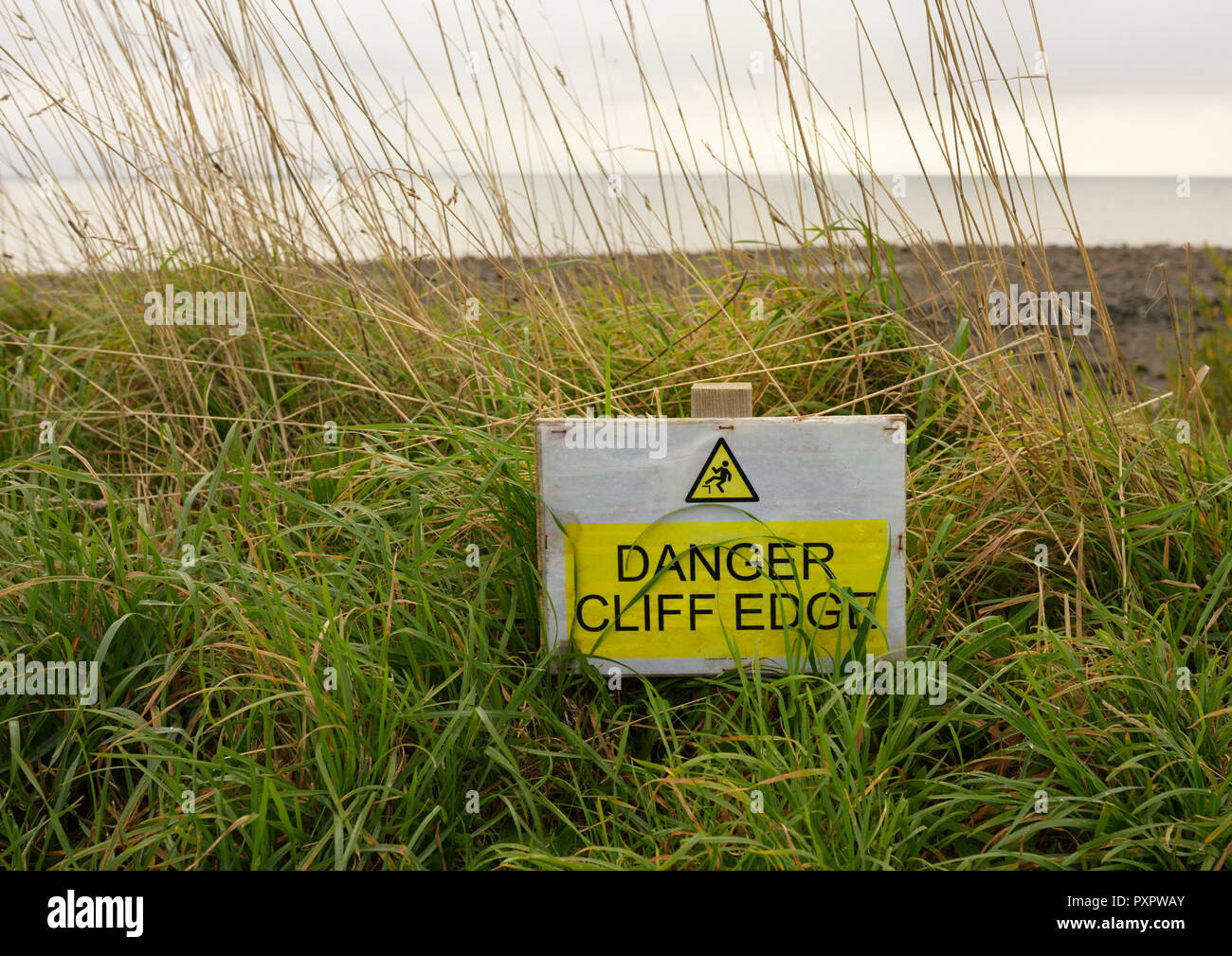 Yellow and white Danger cliff edge sign on wales coast path, coastal ...