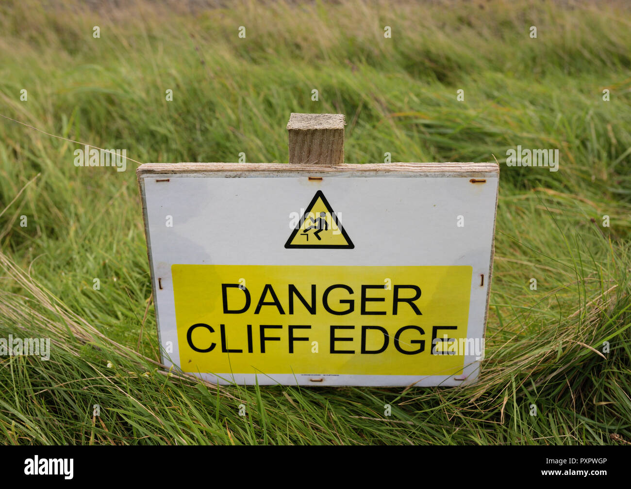 Yellow and white Danger cliff edge sign on wales coast path, coastal ...