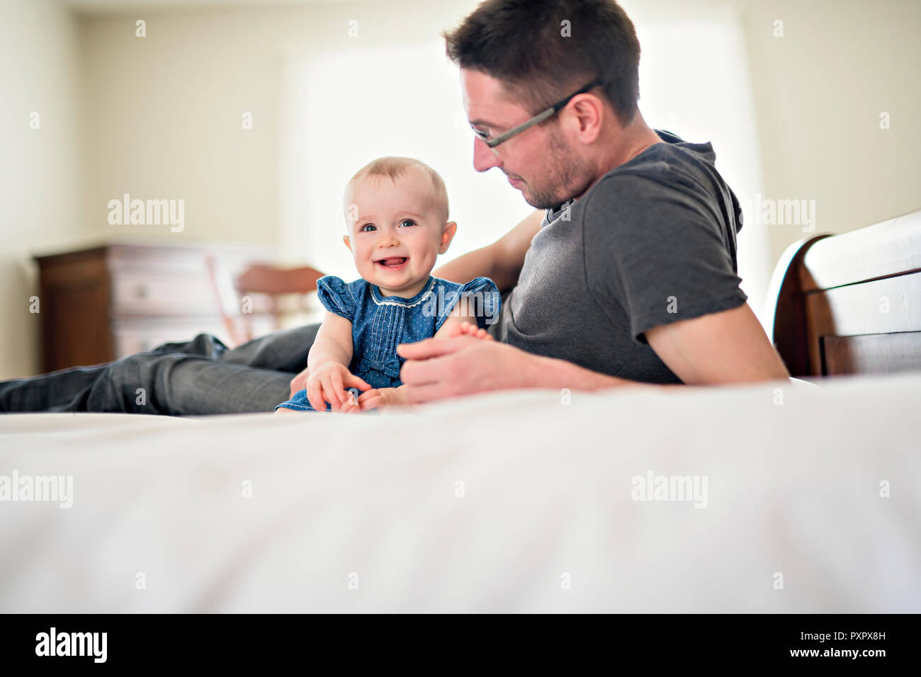 Father playing with her baby in the bedroom Stock Photo - Alamy