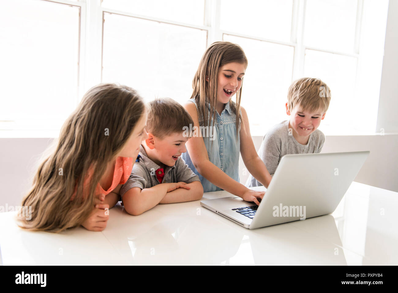 Group of curious children watching stuff on the laptop screen Stock ...