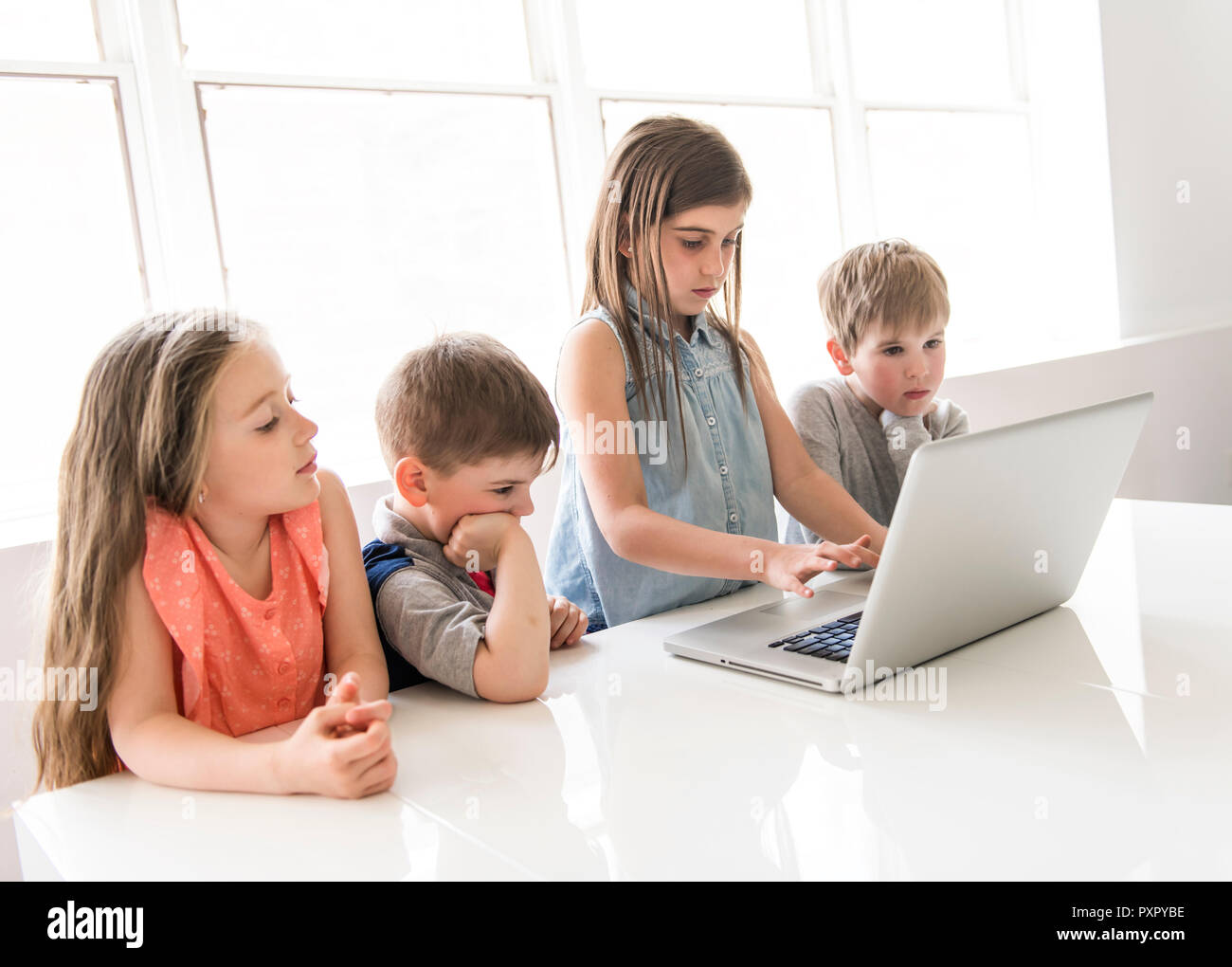 Group of curious children watching stuff on the laptop screen Stock ...
