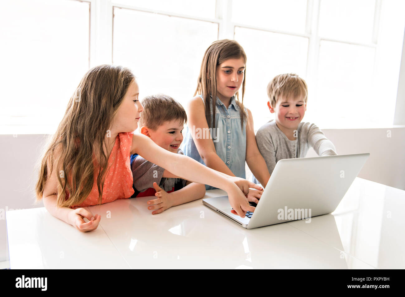 Group of curious children watching stuff on the laptop screen Stock ...