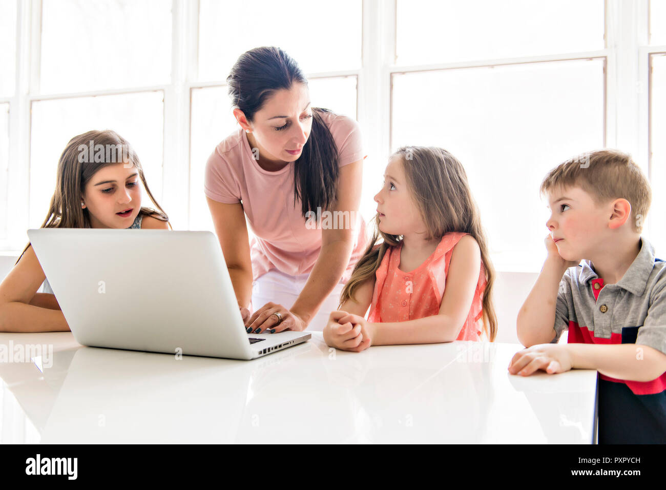 Teacher with a group of school children with laptop on the front Stock ...