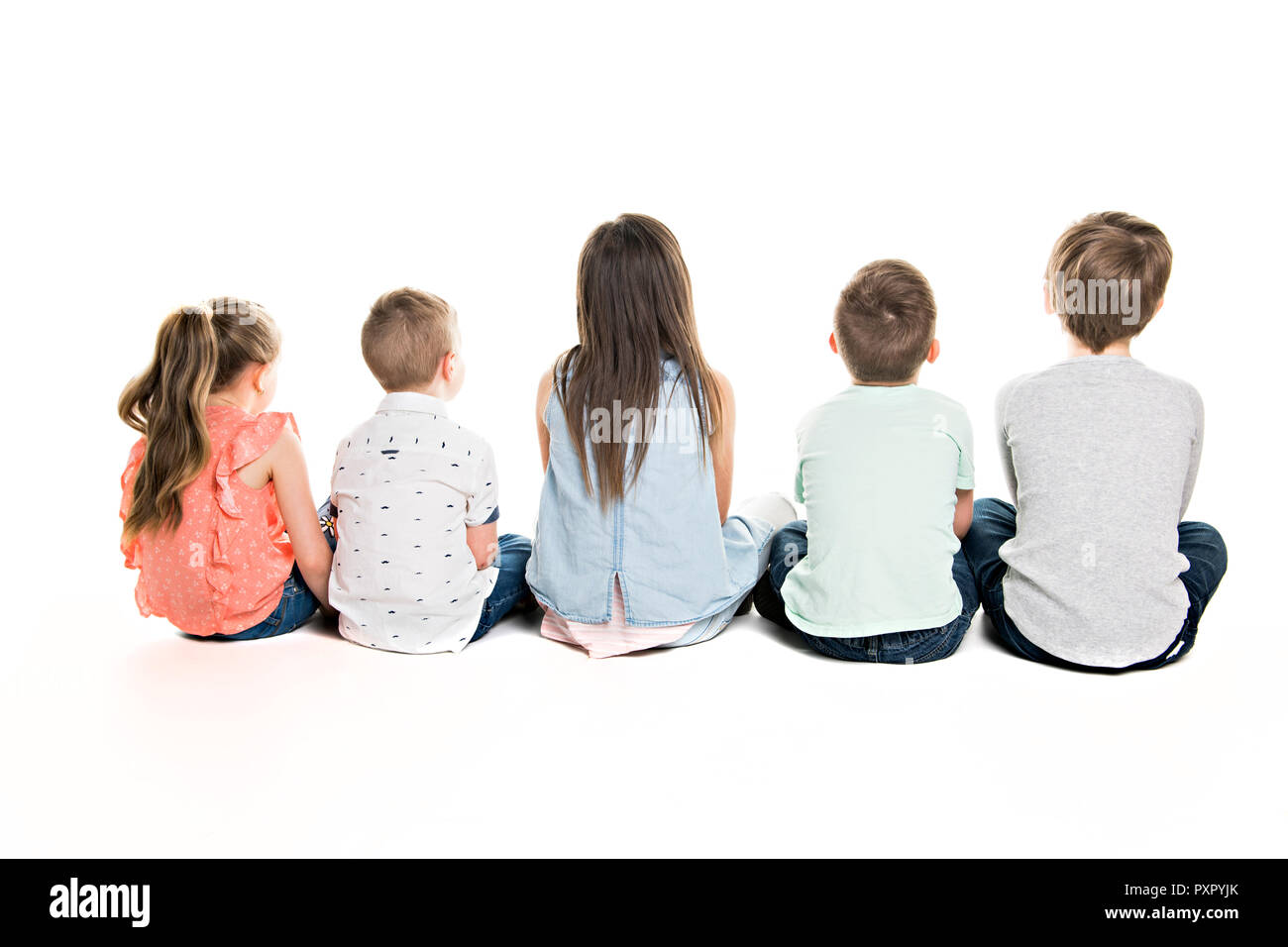 Back view of child group sitting on floor looking at wall Stock Photo ...