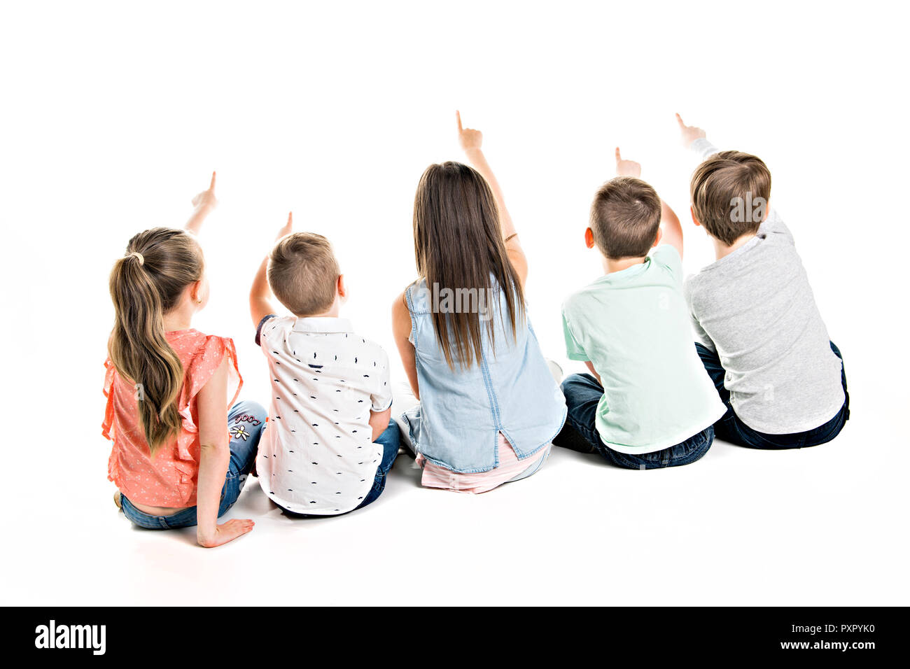 Back view of child group sitting on floor looking at wall Stock Photo ...