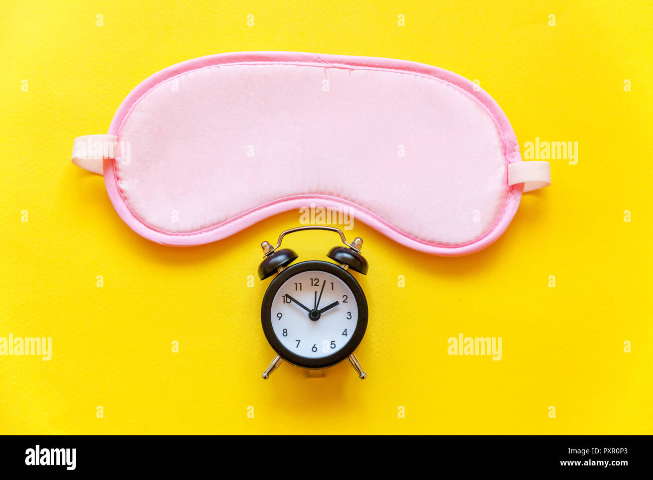 Sleeping eye mask, alarm clock isolated on yellow colourful trendy ...