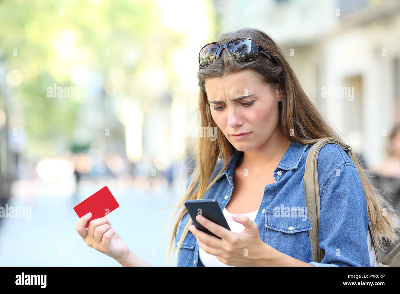 Worried girl having online payment problems with a smart phone in the ...