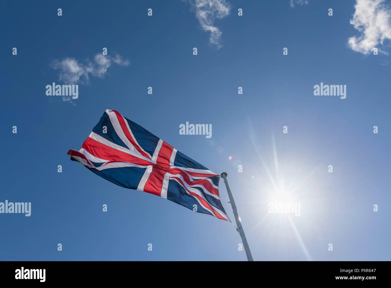 Union Jack in blue sky with backlight Stock Photo - Alamy