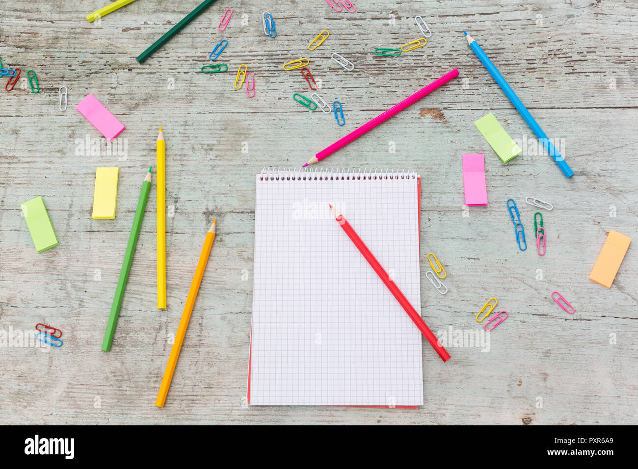 Spiral notebook, paper clip, marker and coloured pencils on wood Stock ...