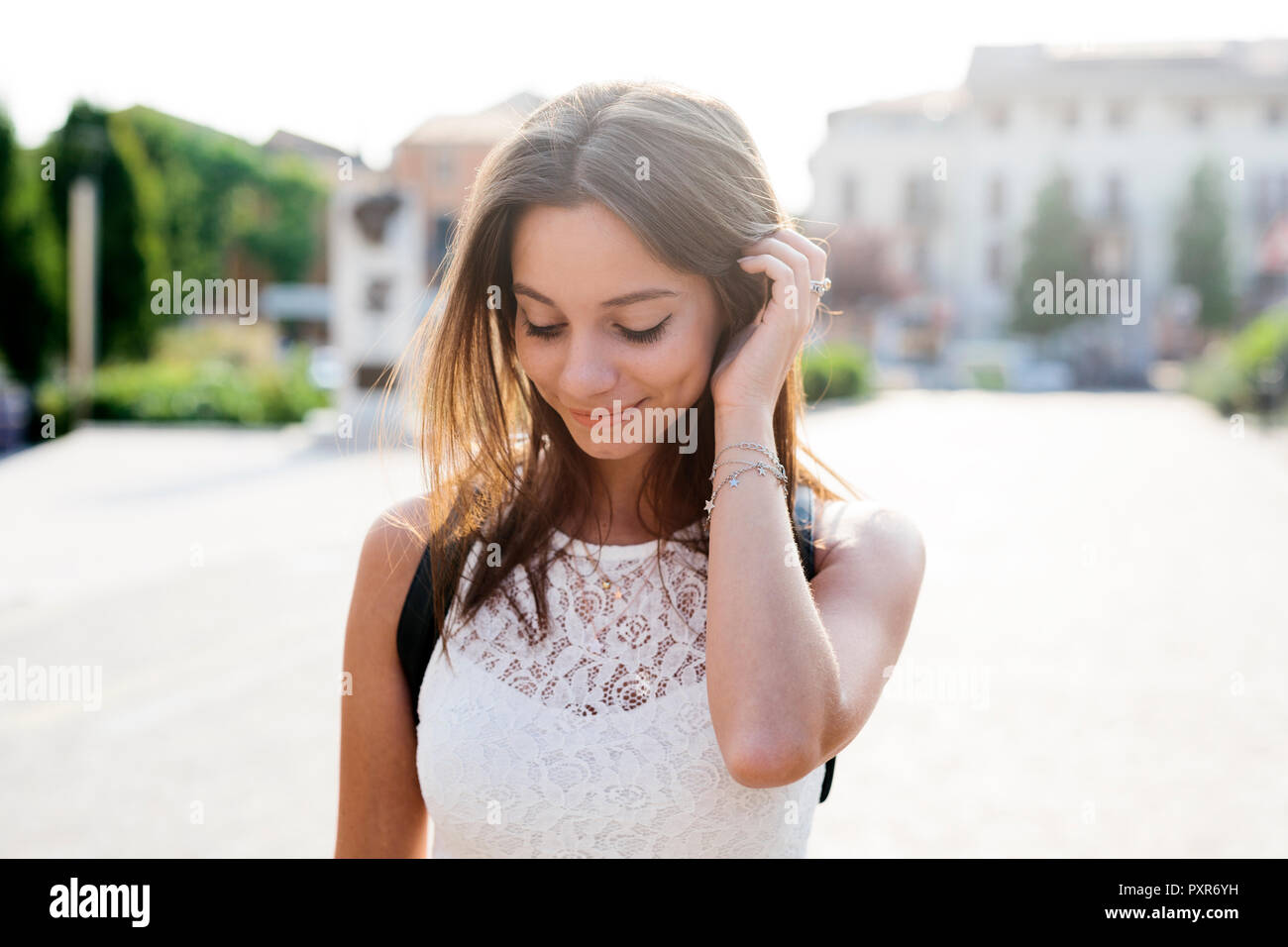 Portrait of smiling young woman in the city looking down Stock Photo ...