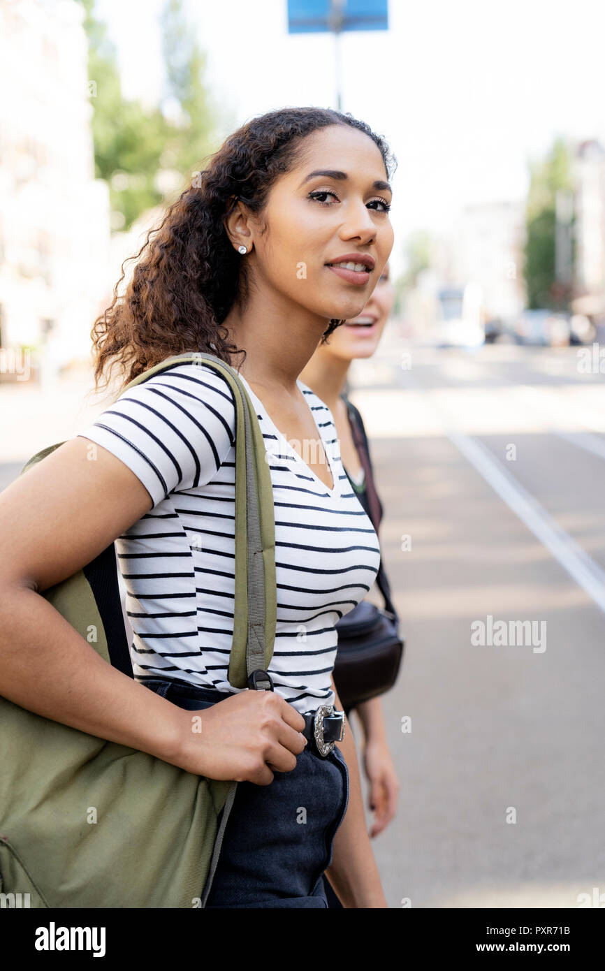 Two young women crossing street in the city Stock Photo - Alamy
