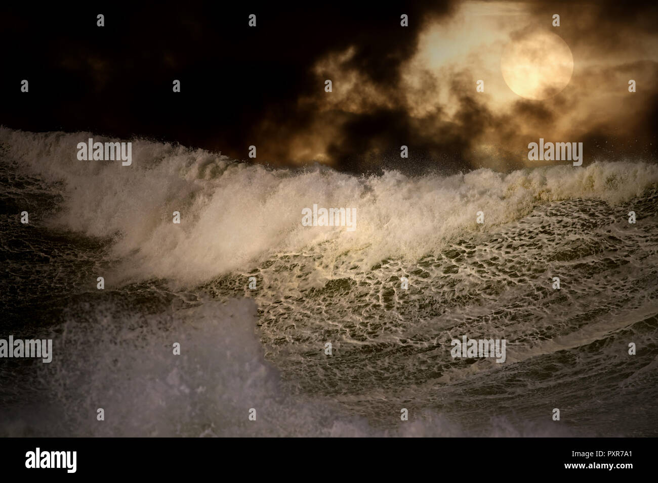 Detailed photo of a big stormy wave crashing over the coast at sunset ...