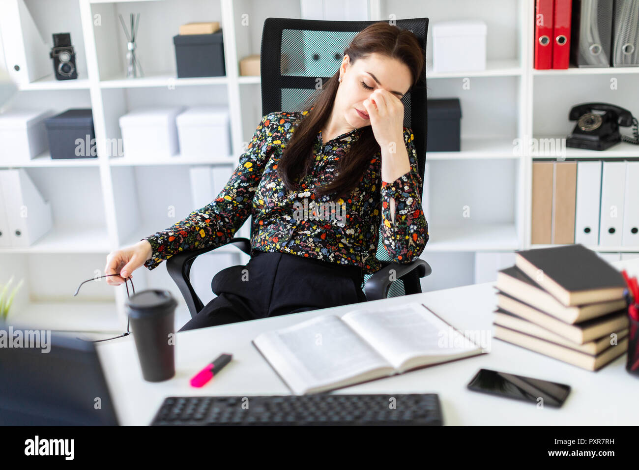 A young girl sitting in the office at the computer table Stock Photo ...