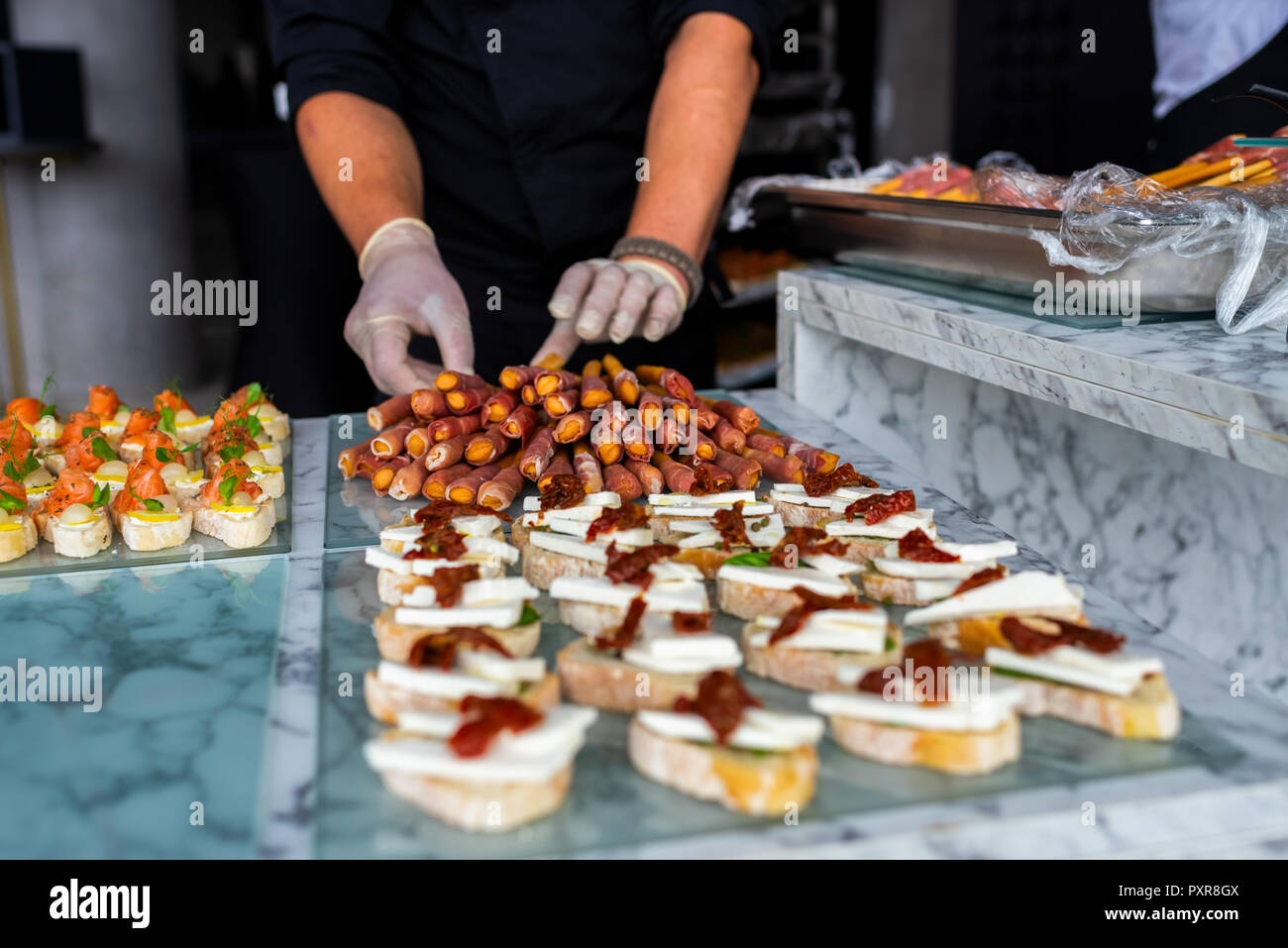 hands in gloves with food on the banquet table Stock Photo - Alamy