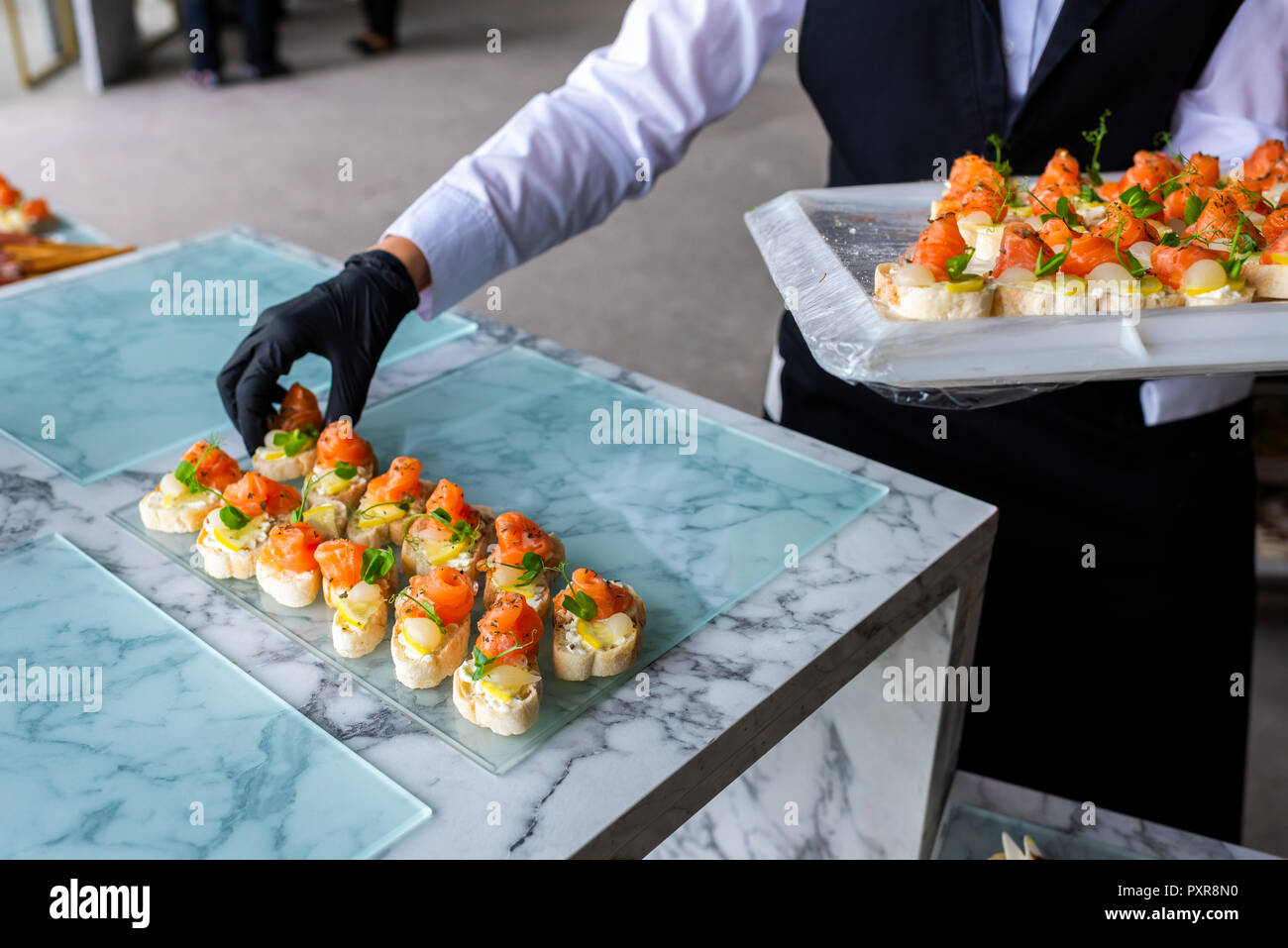 hands in gloves with food on the banquet table Stock Photo - Alamy