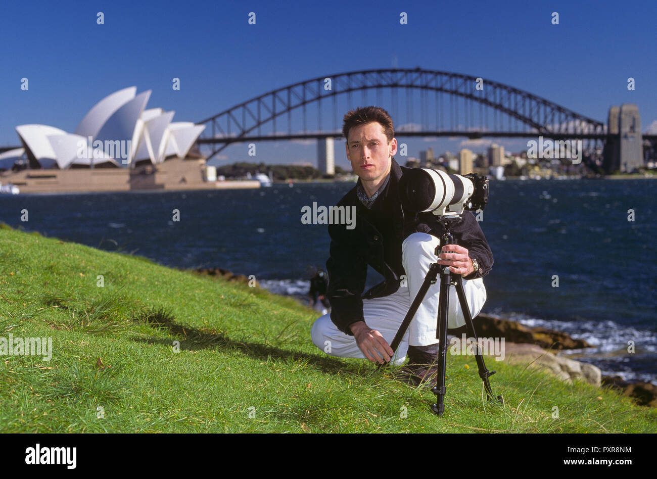 A professional photographer with pro camera and lens on Sydney Harbour ...
