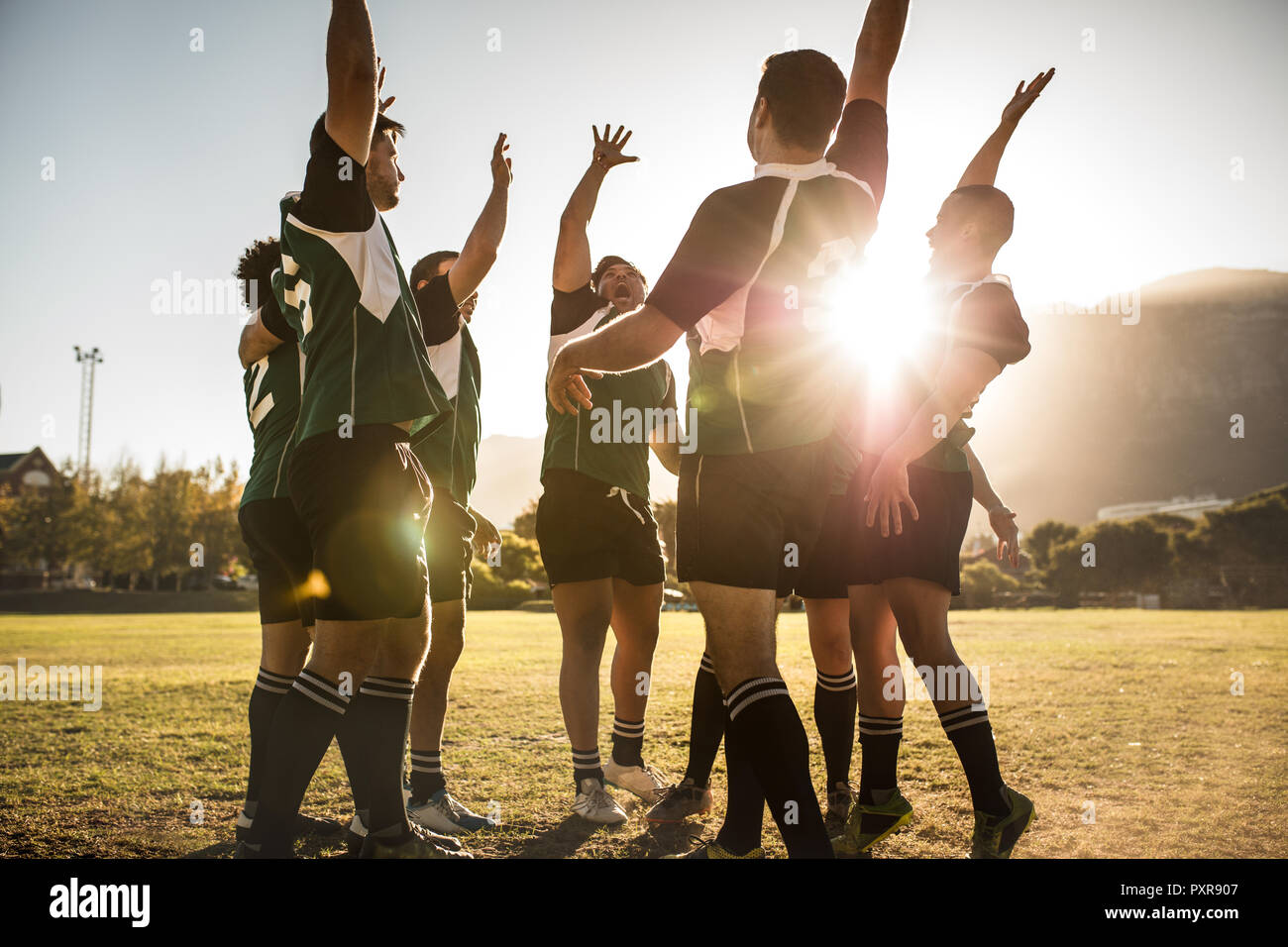 rugby players celebrating a win at the sports field. rugby team with ...