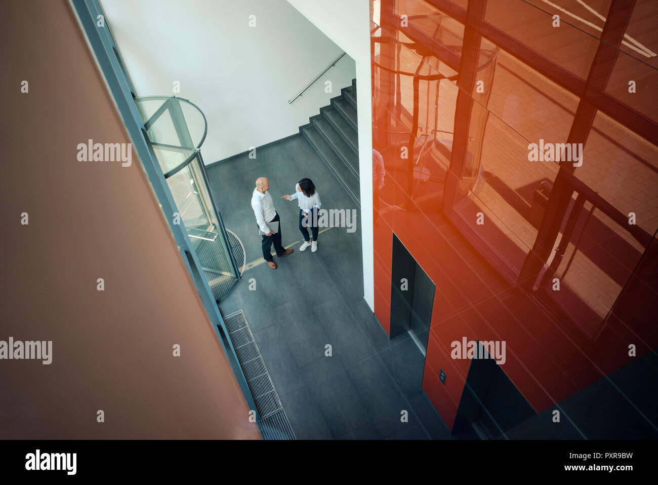 Business people talking in front of elevator Stock Photo - Alamy