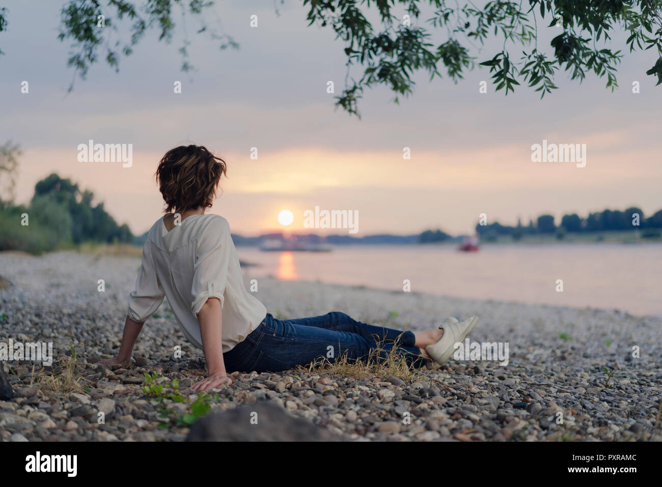Woman sitting river watching hi-res stock photography and images - Alamy