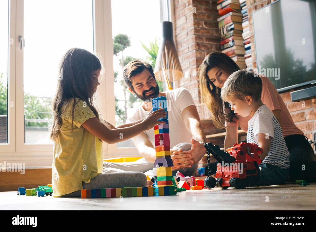 Family playing with building blocks on the floor together Stock Photo ...