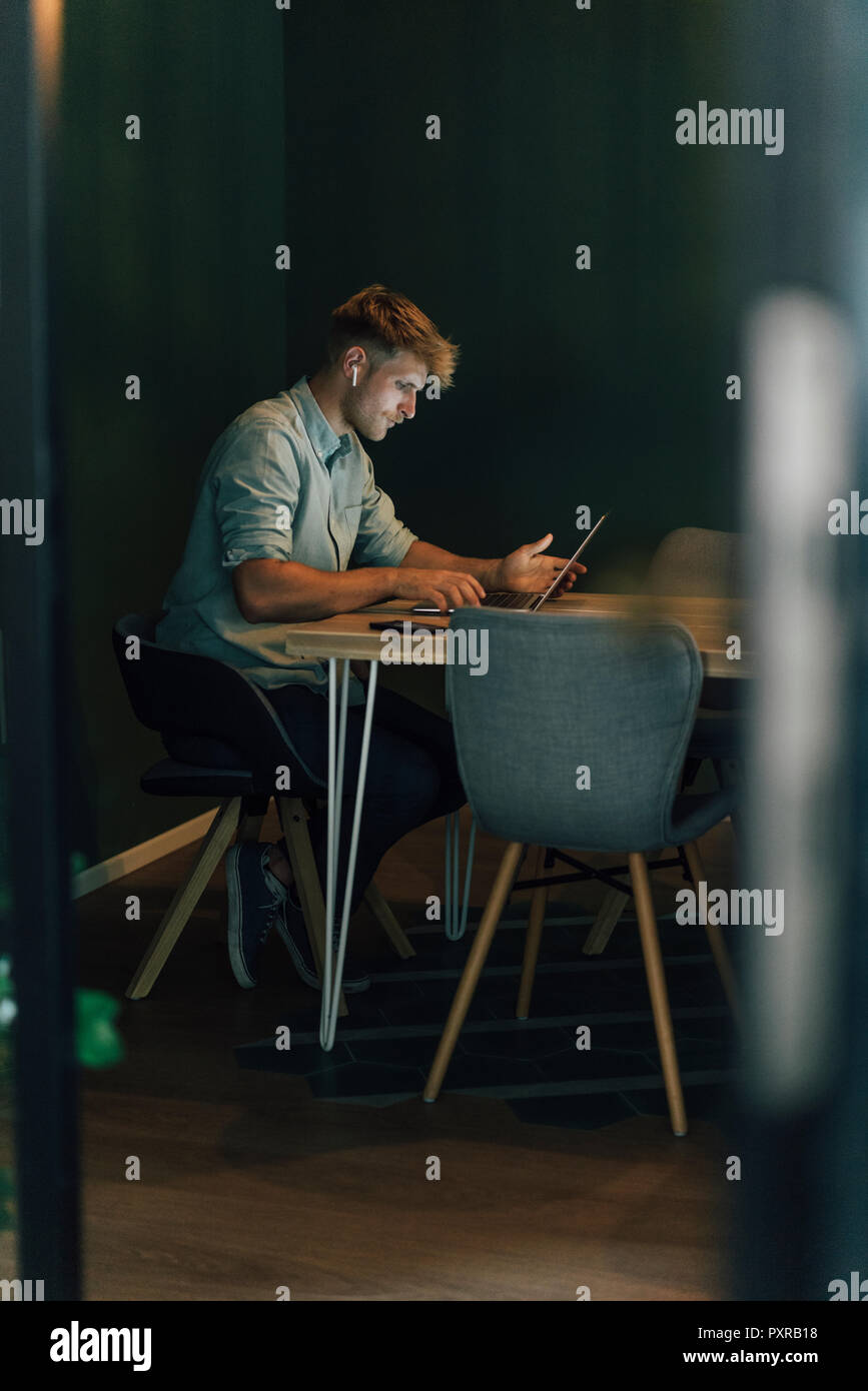 Man sitting in office, working late in his start-up company Stock Photo ...