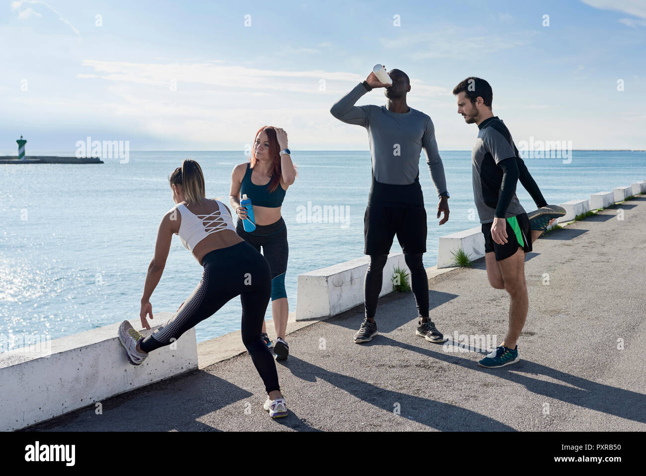 Group of sportspeople during break, stretching and trinking Stock Photo ...