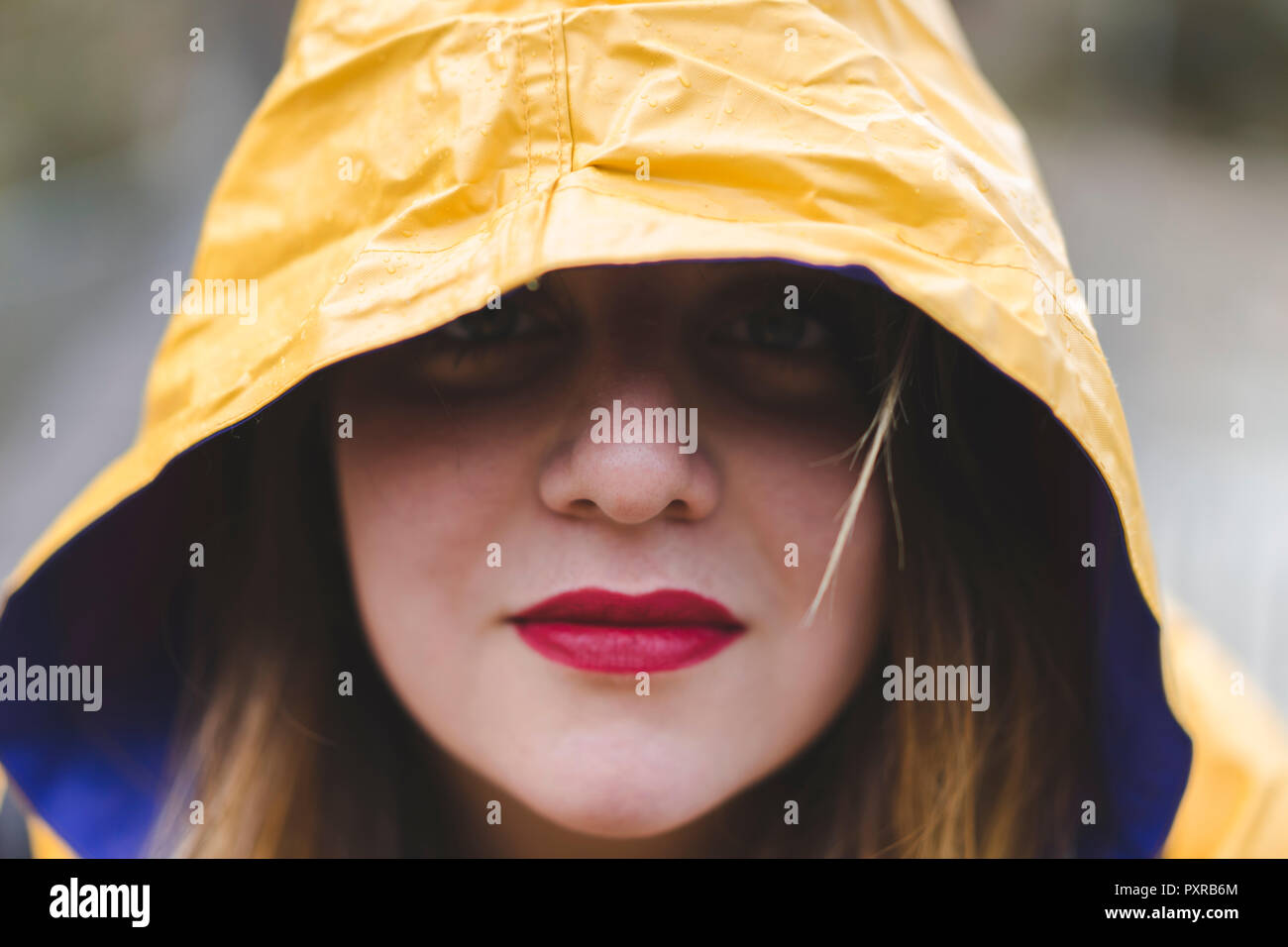 Portrait of woman wearing yellow hood of rainjacket Stock Photo - Alamy