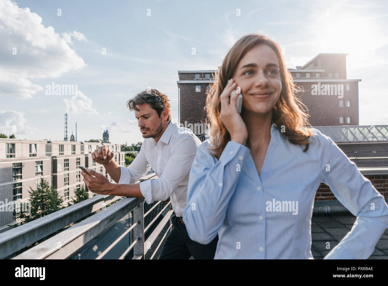 Businessman and woman standing on balcony hi-res stock photography and ...
