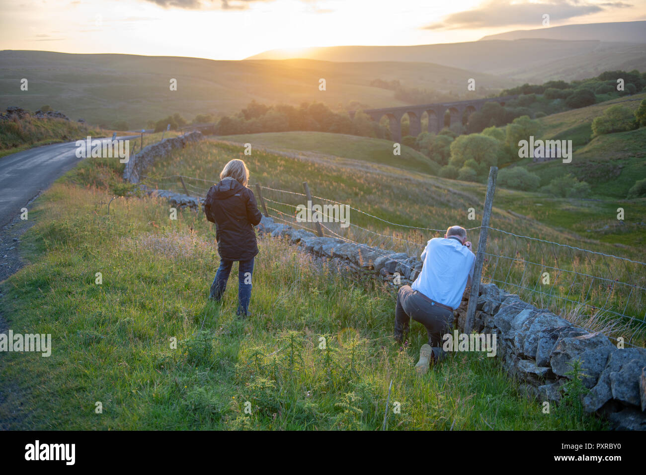 Tourist use their cameras to capture the Dent Head viaduct, moorland ...