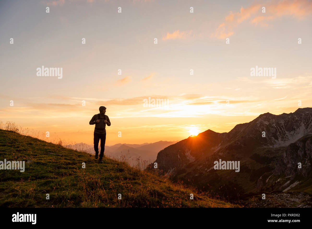 Germany, Bavaria, Oberstdorf, man on a hike in the mountains at sunset ...