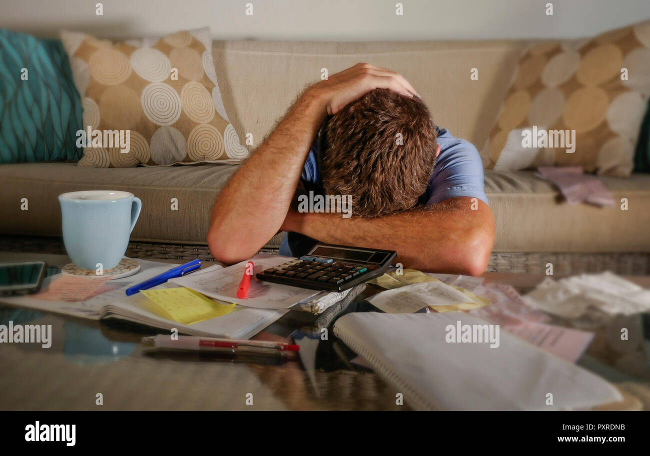 worried and stressed man at home calculating month tax expenses with ...