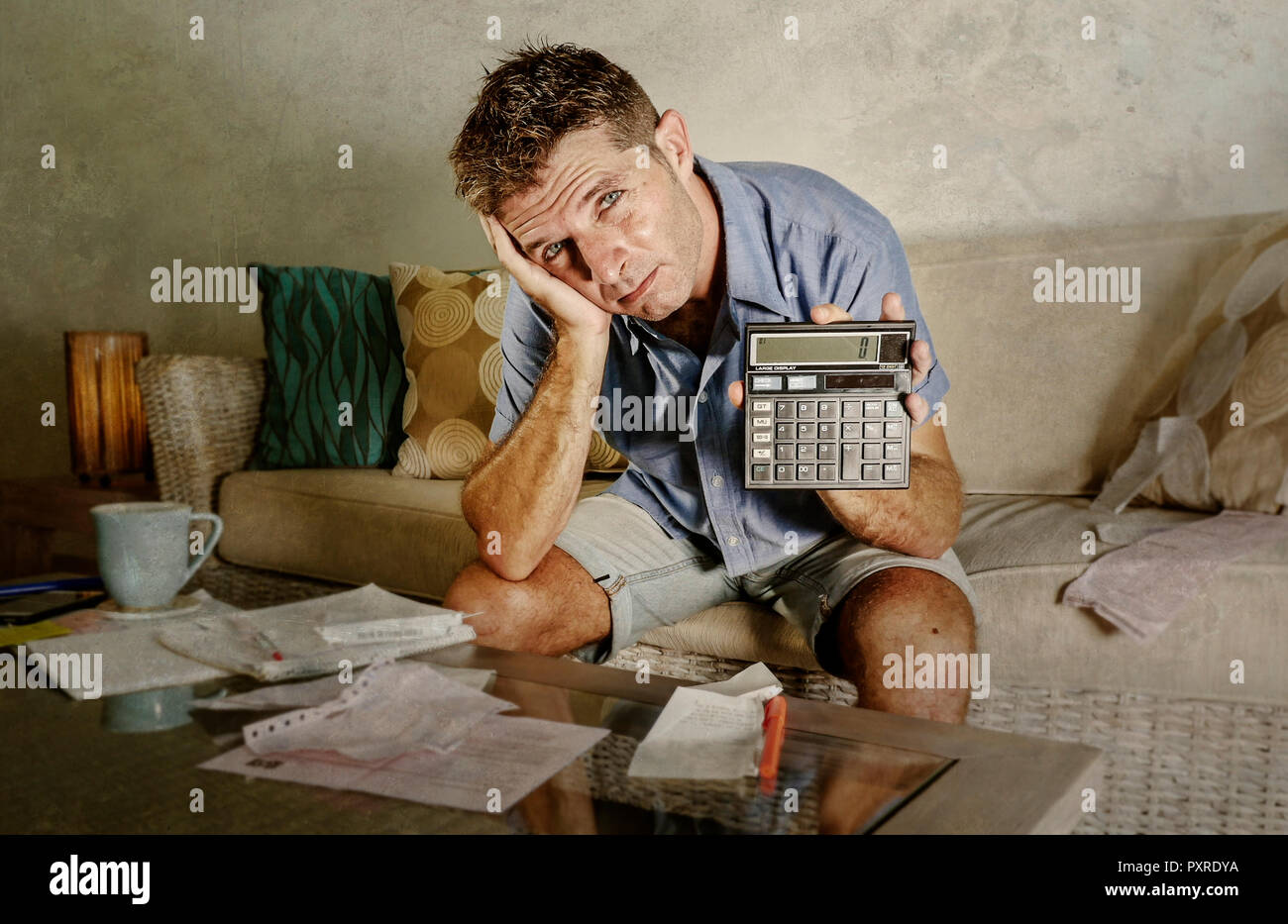 young attractive worried and stressed man at home calculating month tax ...
