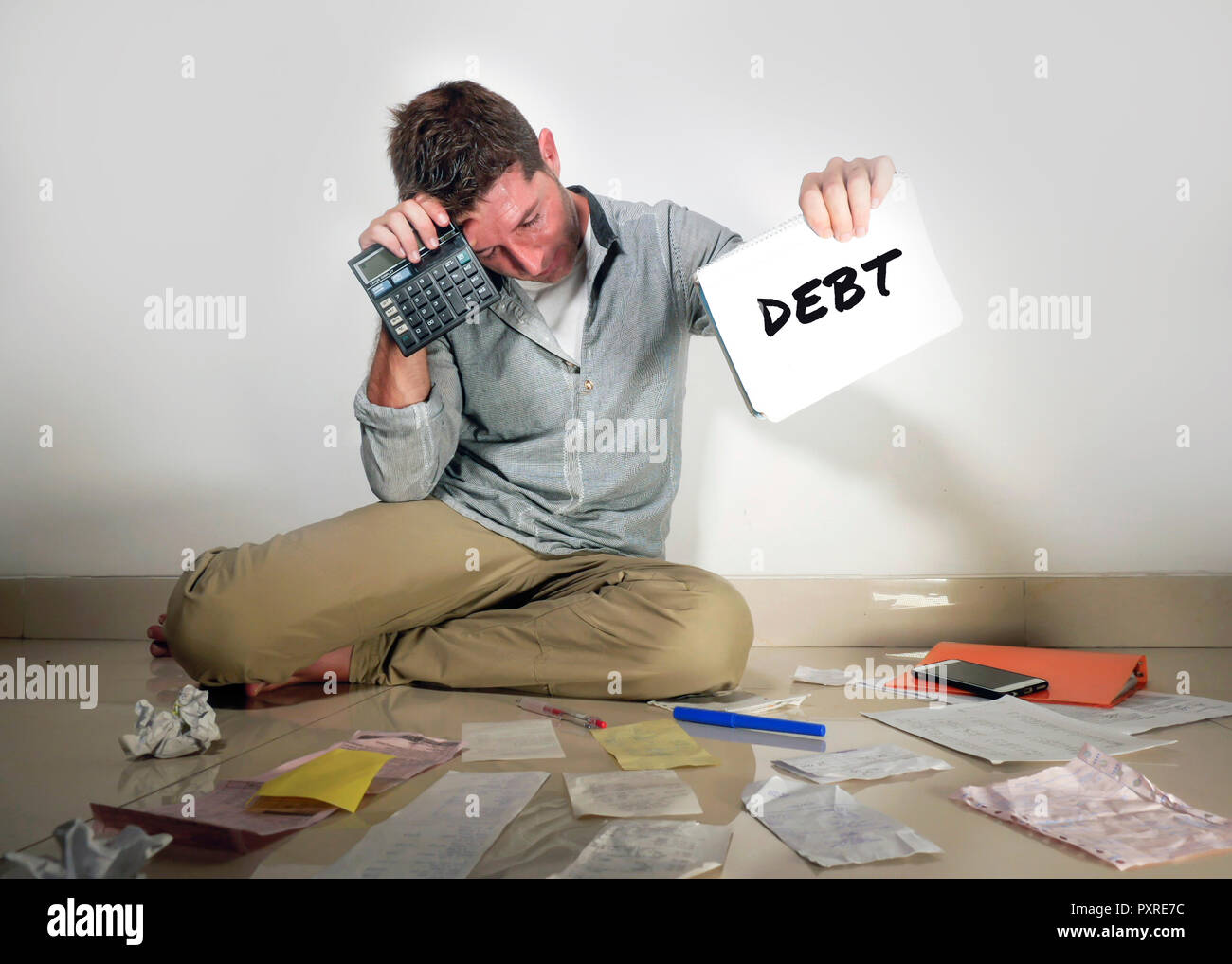 young desperate and stressed sad man worried holding calculator ...