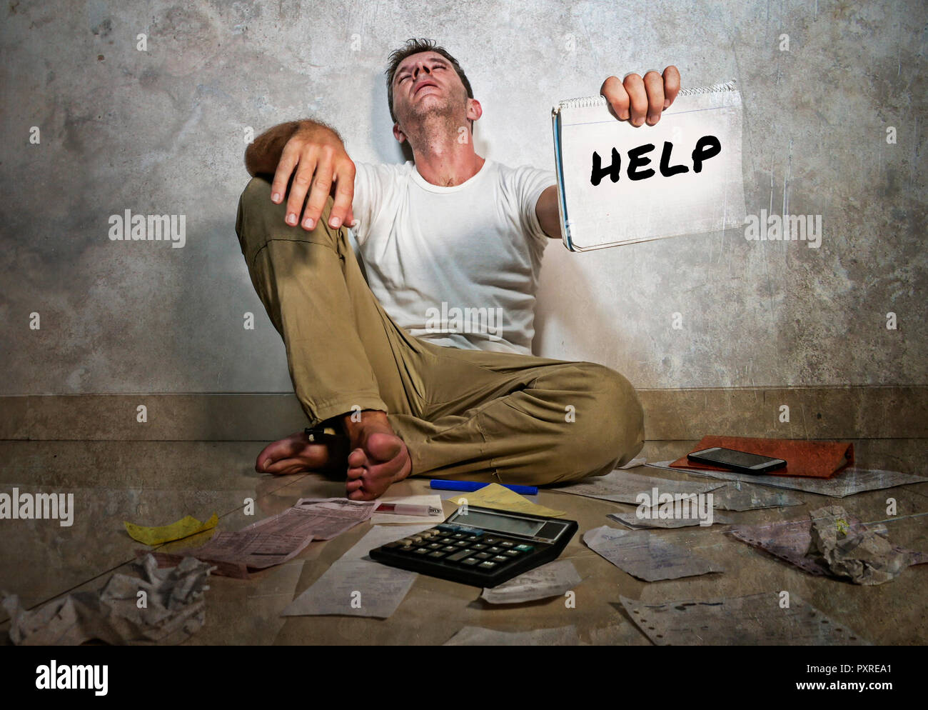 young desperate and stressed sad man worried holding notepad asking for ...