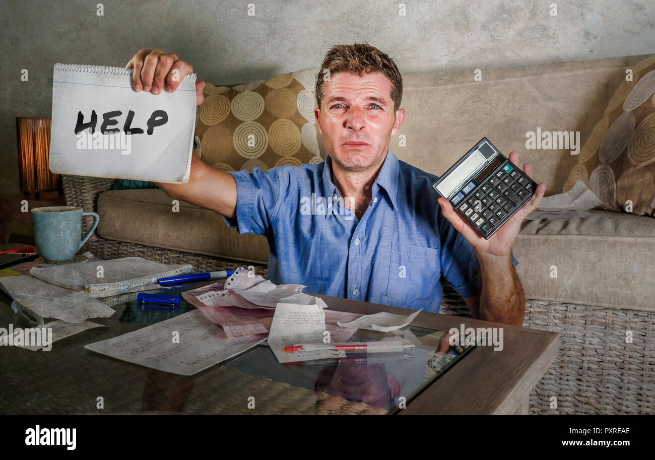 young attractive worried and stressed man at home calculating month tax ...