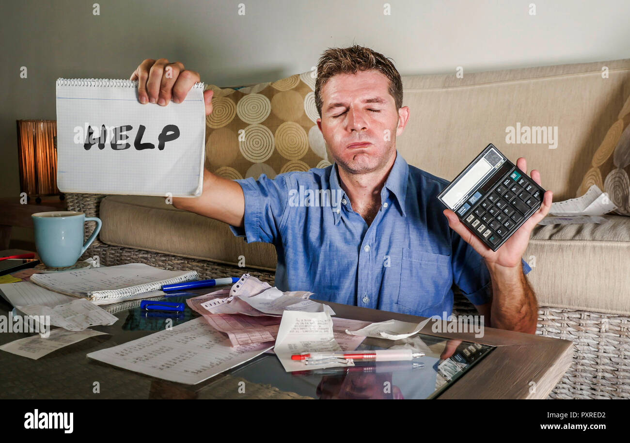 young attractive worried and stressed man at home calculating month tax ...