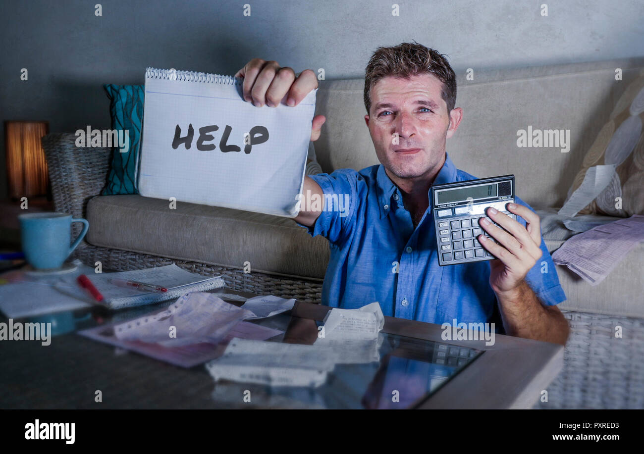 young attractive worried and stressed man at home calculating month tax ...