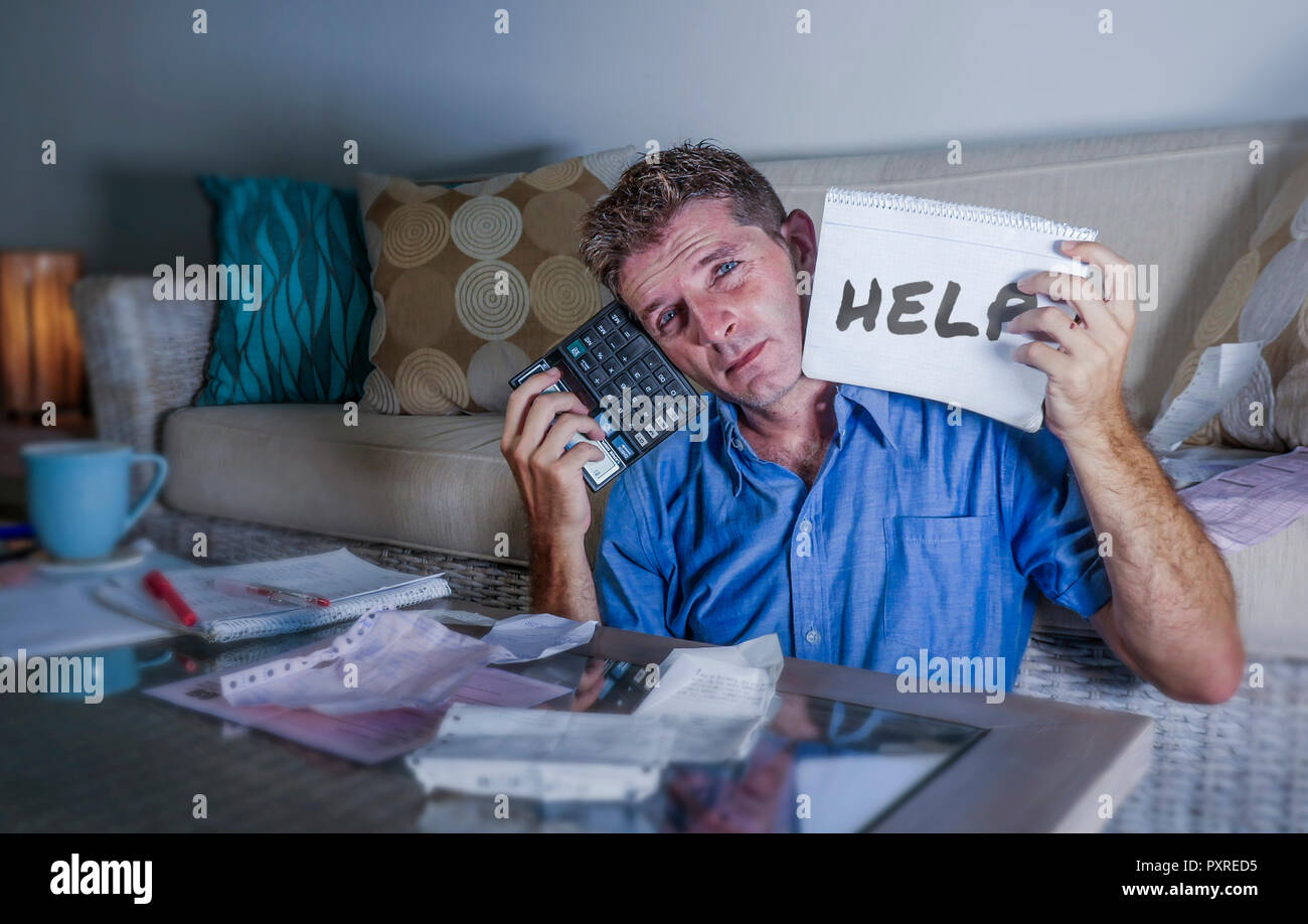 young attractive worried and stressed man at home calculating month tax ...