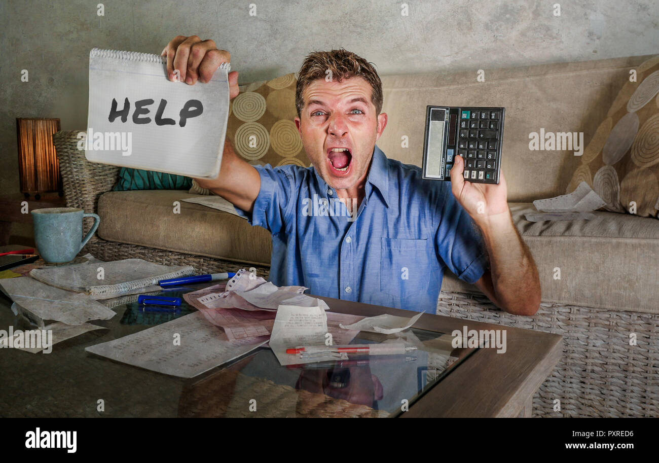 young attractive worried and stressed man at home calculating month tax ...