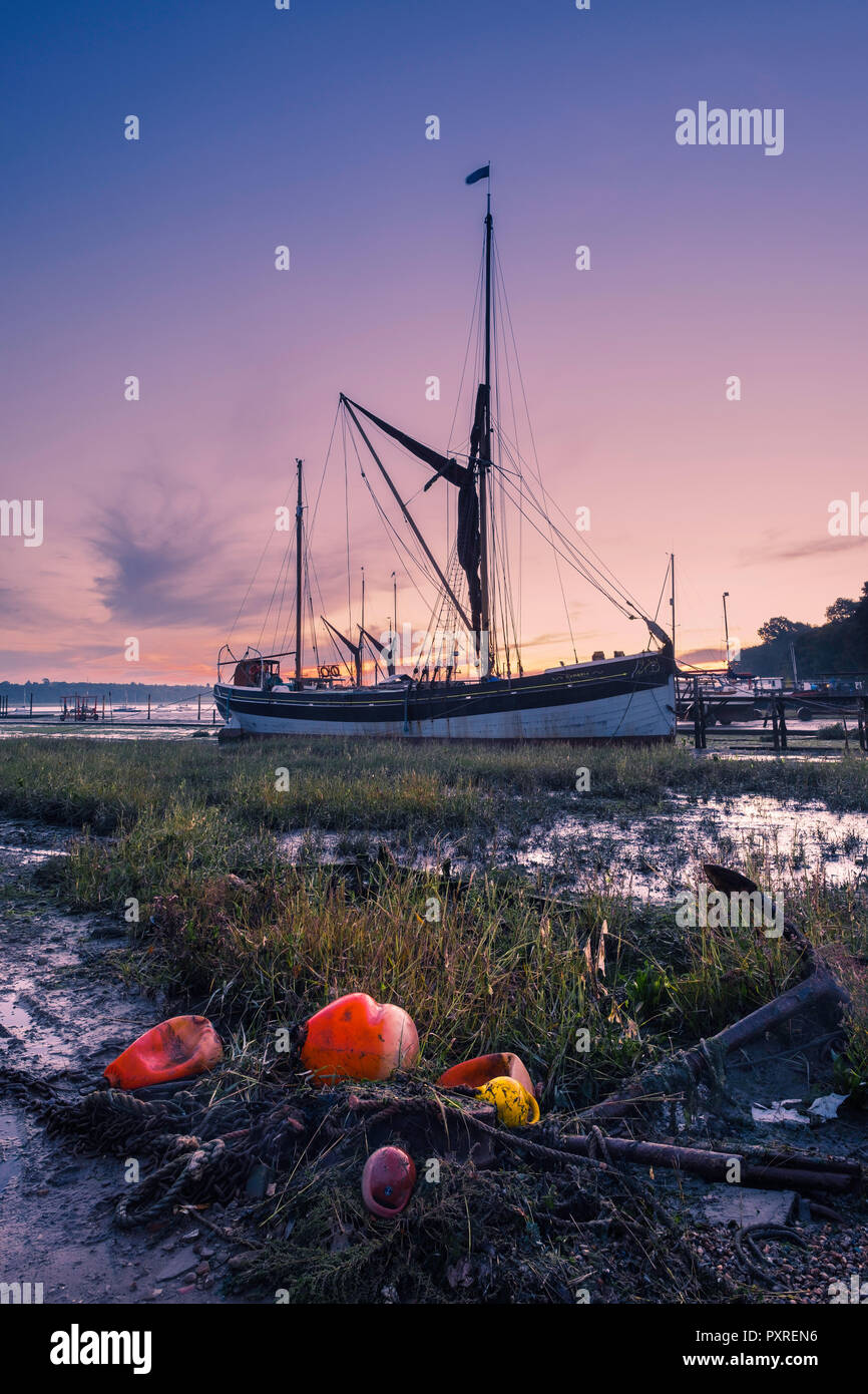 Thames sailing barges lie on the mud at Pin MIll as the day breaks ...
