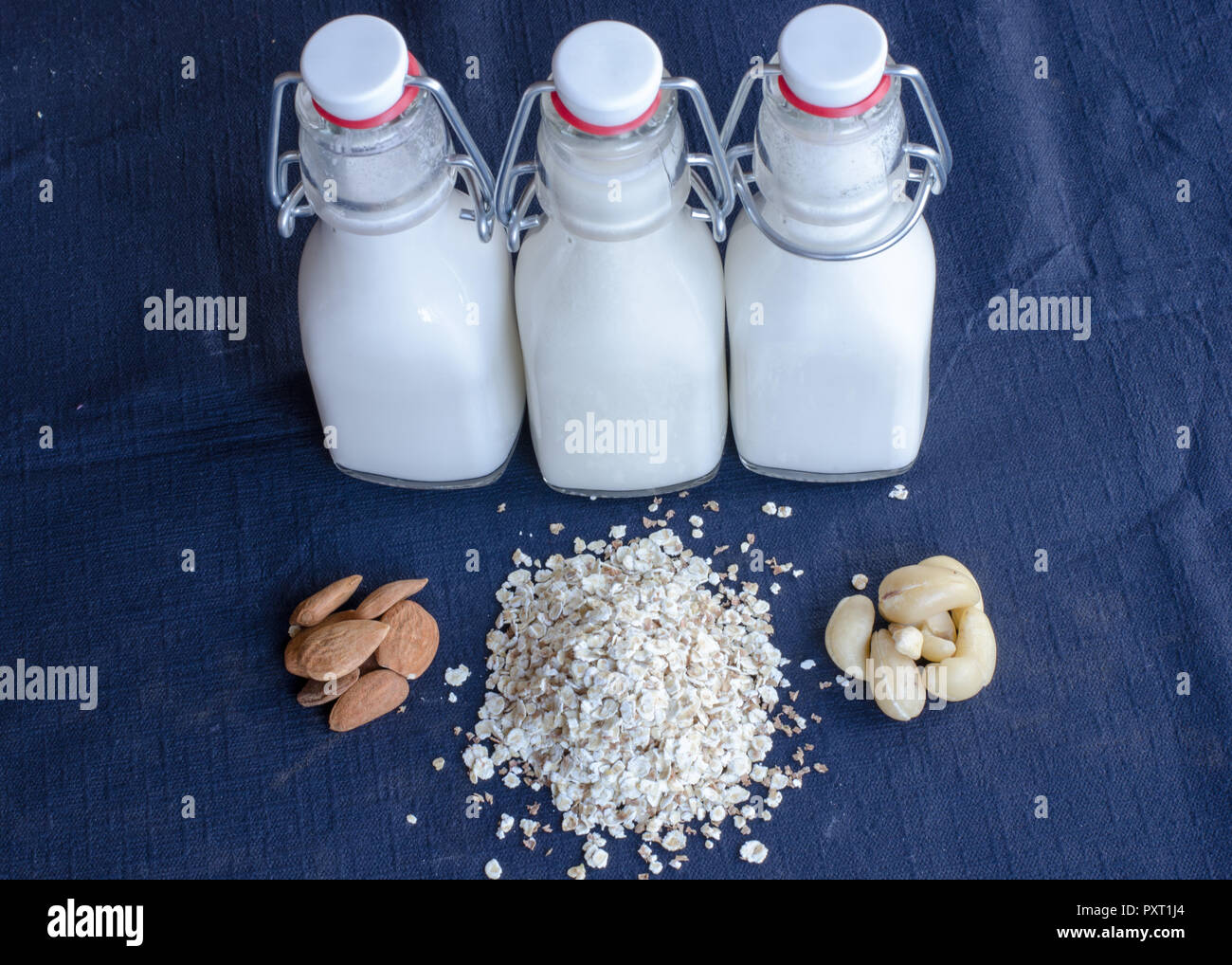 Almond milk, cashew nut milk and oat milk standing together with ...