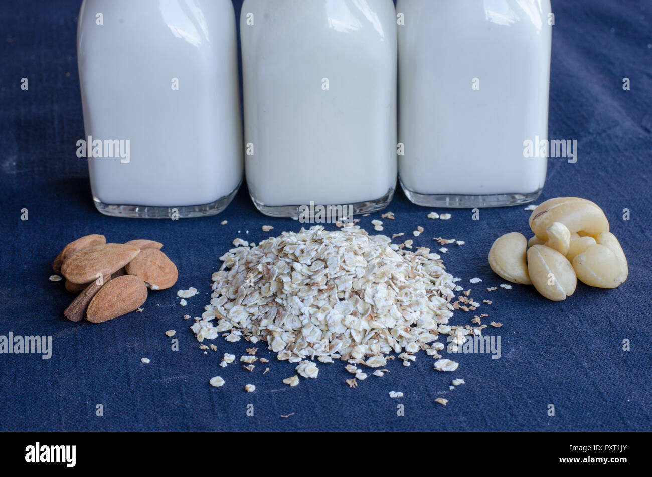 Almond milk, cashew nut milk and oat milk standing together with ...